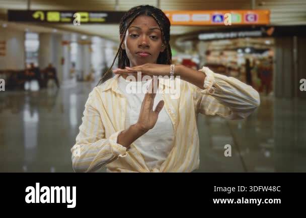 Woman makes timeout gesture with hands while waiting near departure ...