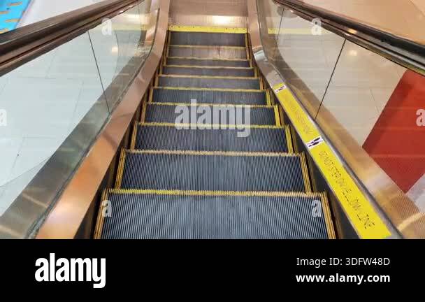 High-angle view of a modern clean escalator steps moving down in a ...