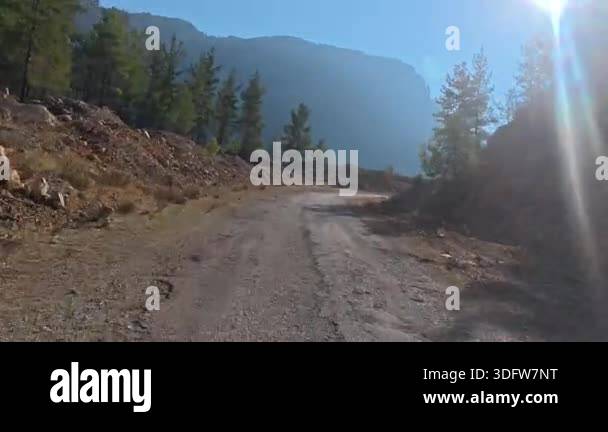 Gravel forest path. Roadside rocky cliffs. Mountain landscape. High ...