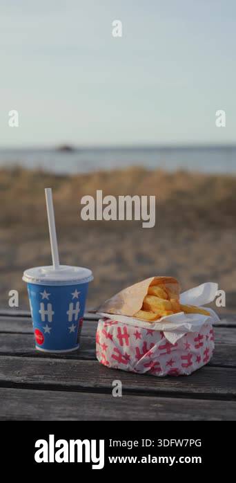 Tallinn, Estonia - April 2, 2025: Enjoying a burger, soft drink, and ...