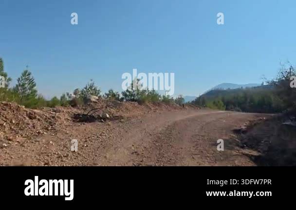 Gravel forest path. Roadside rocky cliffs. Mountain landscape. High ...