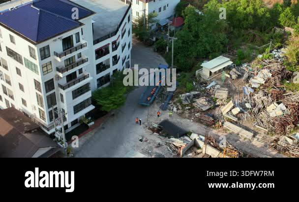 Aerial view of workers unloading rebar from a flatbed truck at a ...