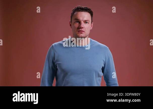 Shocked man reacting to bad news with distressed expression on brown ...