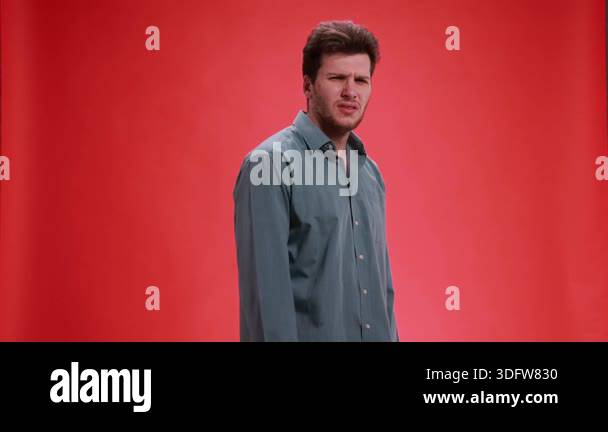 Disgusted man reacting with visible aversion on red background. Concept ...