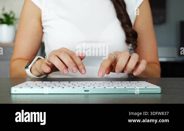 Close up of woman hands typing on wireless keyboard on desk in home ...
