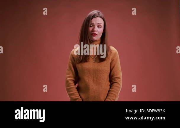 Disappointed woman openly showing frustration on brown background ...