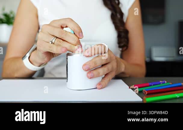Close up of woman hands sharpening colored pencils with electric ...