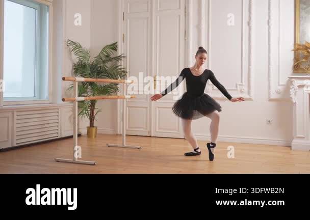 Young ballerina in tutu skirt stretching practicing ballet positions ...