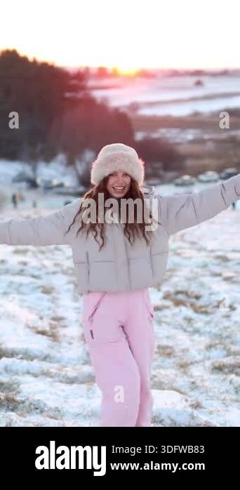 Joyful woman in winter attire revels in a snow-covered landscape during ...