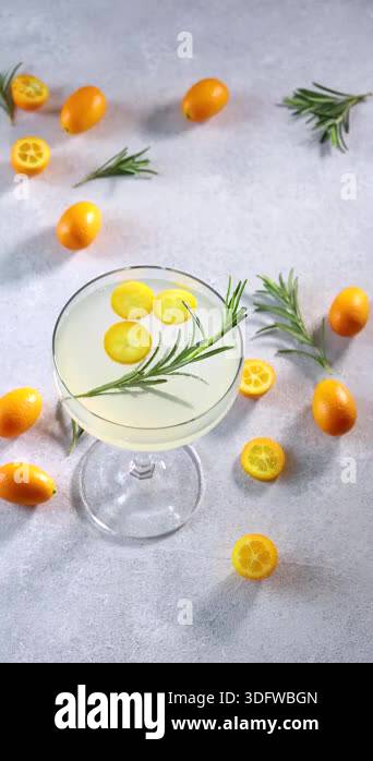 Elegant glass with a fresh kumquat and rosemary cocktail slowly ...