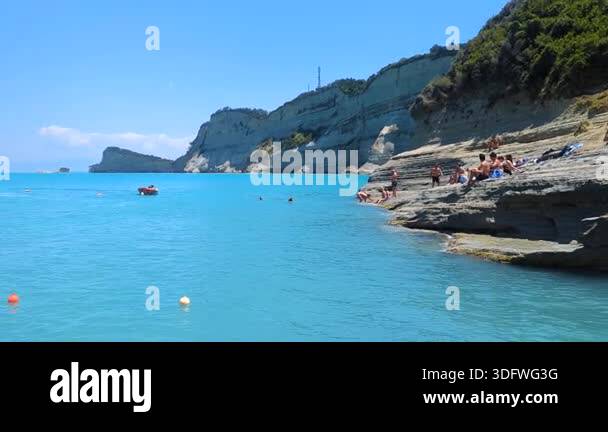 Cape Drastis, Corfu, Greece - July 12, 2025: People resting on layered ...