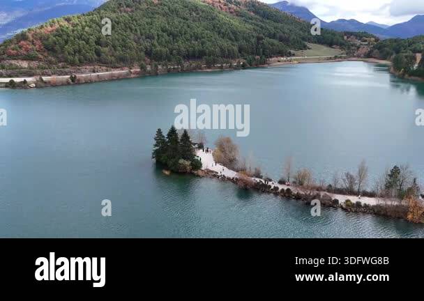 Aerial orbit shot of Agios Fanourios church in the middle of Lake Doxa ...