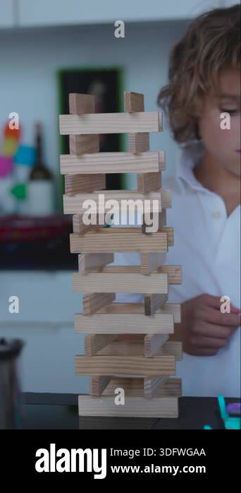 Child builds tall block tower piece by piece expressing patience ...
