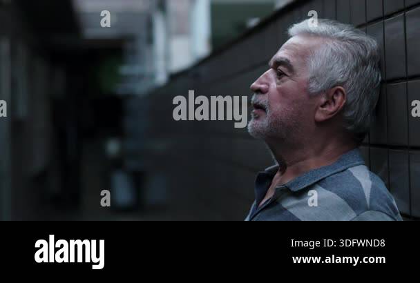 Older man rests briefly while standing still, expressing fatigue ...