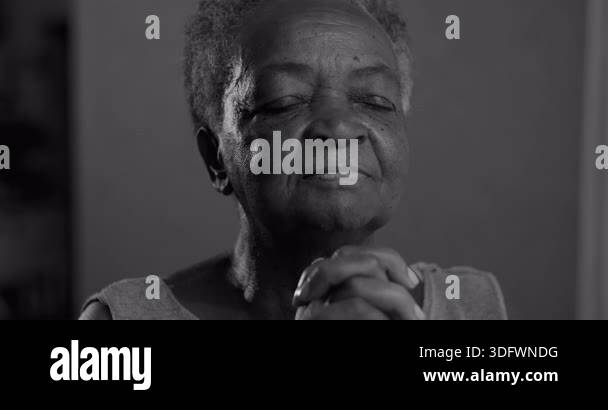 Senior woman clasps hands in black and white, expressing trust in God ...