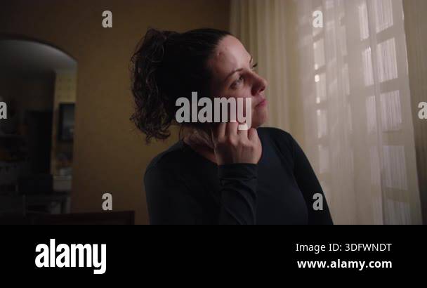 Woman hides face with hand indoors, expressing desperation, mental ...