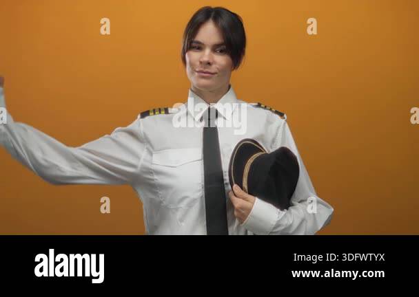 Young hispanic woman plane pilot flexes muscle over isolated orange ...
