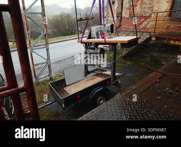 Heavy industrial sewing machine lowered from first floor onto trailer ...