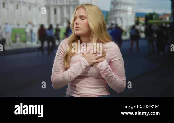 Woman feeling discomfort, clutching chest in front of pisa tower ...