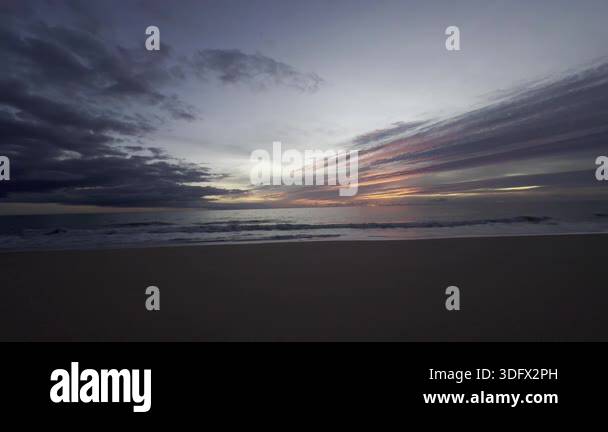 A sunset over the ocean, with vibrant golden and purple tones blending ...