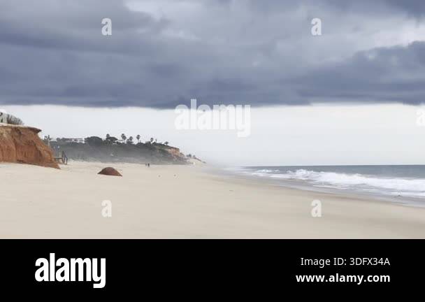 Atlantic ocean sunset with surging waves with people silhouettes at ...