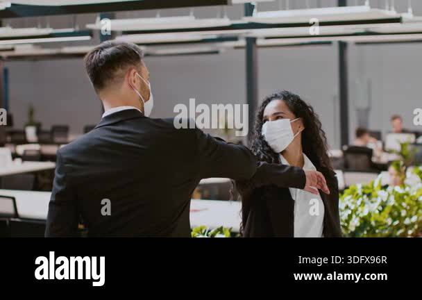 In a modern corporate office, two colleagues dressed in suits are ...