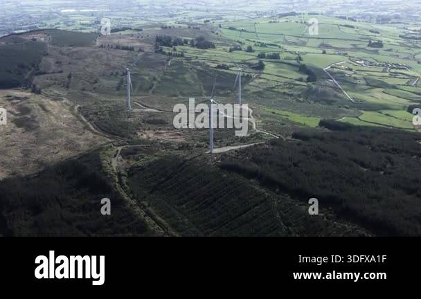 High angle shot of wind turbines in a green, hilly landscape. Clean ...