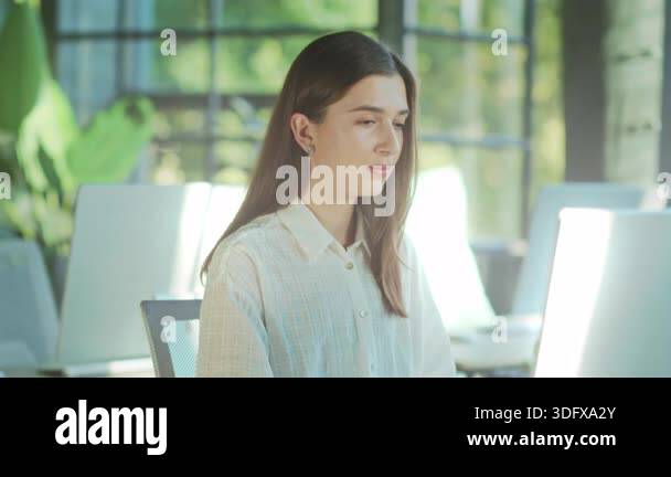 young woman at desk focused, soft morning light, indoor office ...