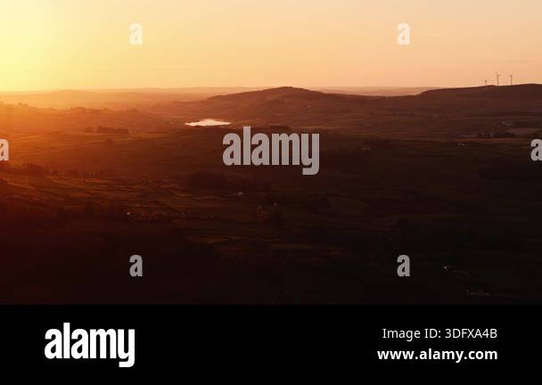 Observe a picturesque landscape at sunset. Hills, a small lake, and ...