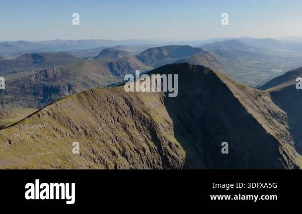 A stunning aerial view of a rugged mountain range under a clear blue ...