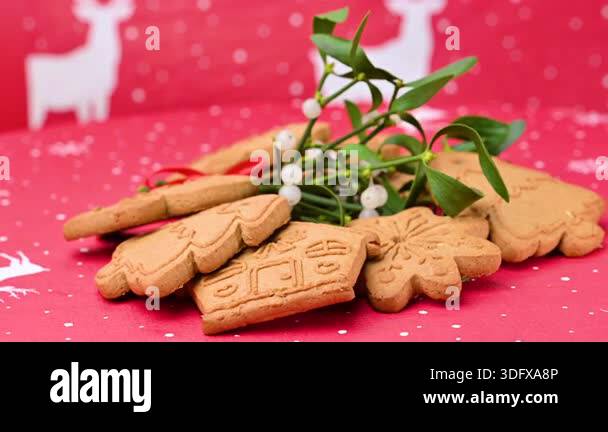 A video of gingerbread cookies with a sprig of mistletoe on a red ...