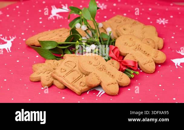 A video of gingerbread cookies with a sprig of mistletoe on a red ...