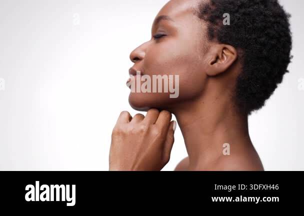 A young African American woman poses elegantly with her chin resting on ...
