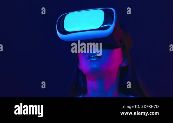 A young Asian woman is immersed in a virtual reality experience ...