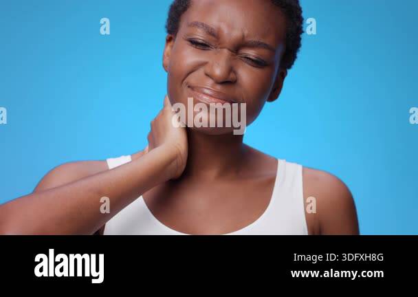 A young African American woman gently stretches her neck, showing a ...