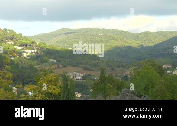 Serene view of Spanish hills covered with trees and rural homes under ...