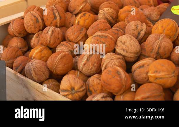 Fresh walnuts displayed in a wooden crate at a farmers market in France ...