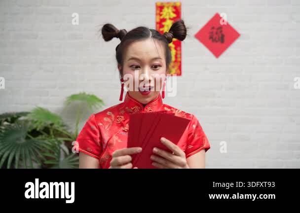 Happy young Asian woman in traditional red Cheongsam dress holding Ang ...
