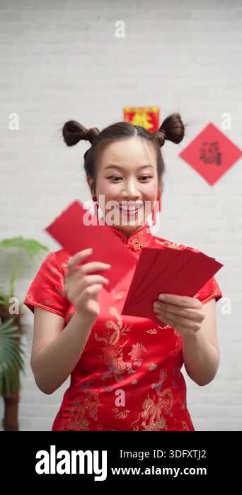 Happy young Asian woman in traditional red Cheongsam dress holding Ang ...