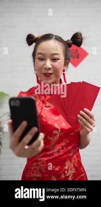 Happy young Asian woman in red cheongsam holding lucky red envelopes ...
