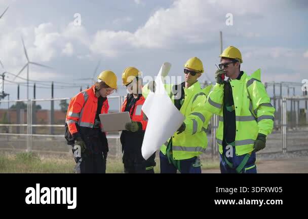 Engineers working on site in electricity substation. Technician wearing ...