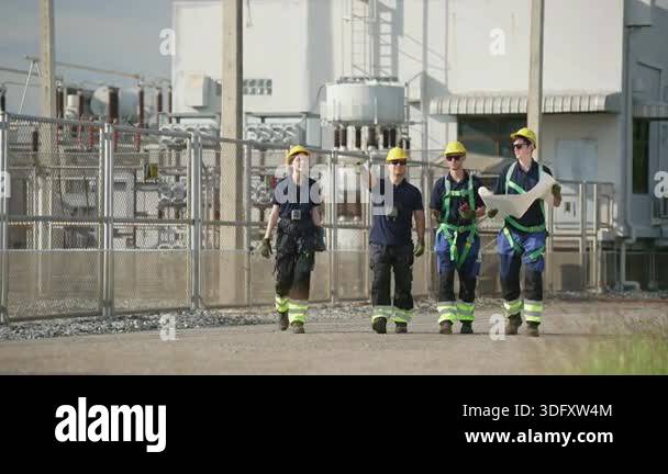 Engineers working on site in electricity substation. Technician wearing ...