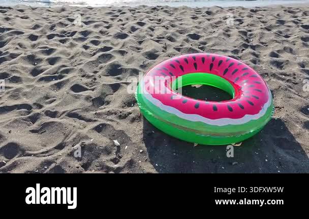 Colorful inflatable swim ring with a watermelon design resting on the ...
