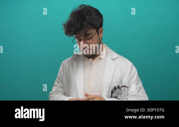 Young man with beard in lab coat deep in thought against blue ...