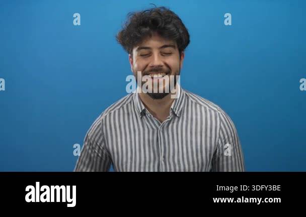 Young man with beard smiling confidently in striped shirt against a ...