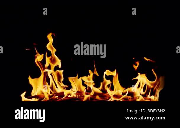 Slow motion flames dancing against a deep black background, creating a ...