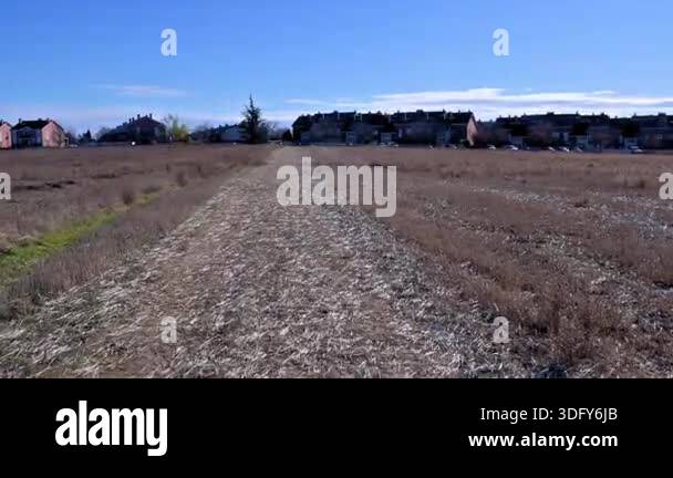 Point of view walking on a dirt path in the countryside with houses in ...