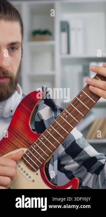 Modern bearded awesome man using laptop has online guitar lessons ...