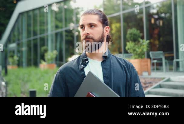Handsome office worker with laptop, standing in cityscape and giving a ...
