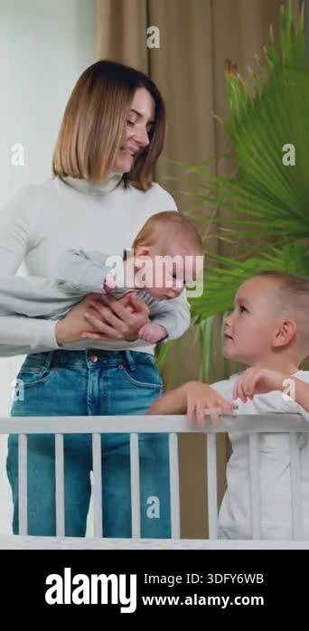 Happy mother holding a smiling baby in her arms. Loving mother carries ...